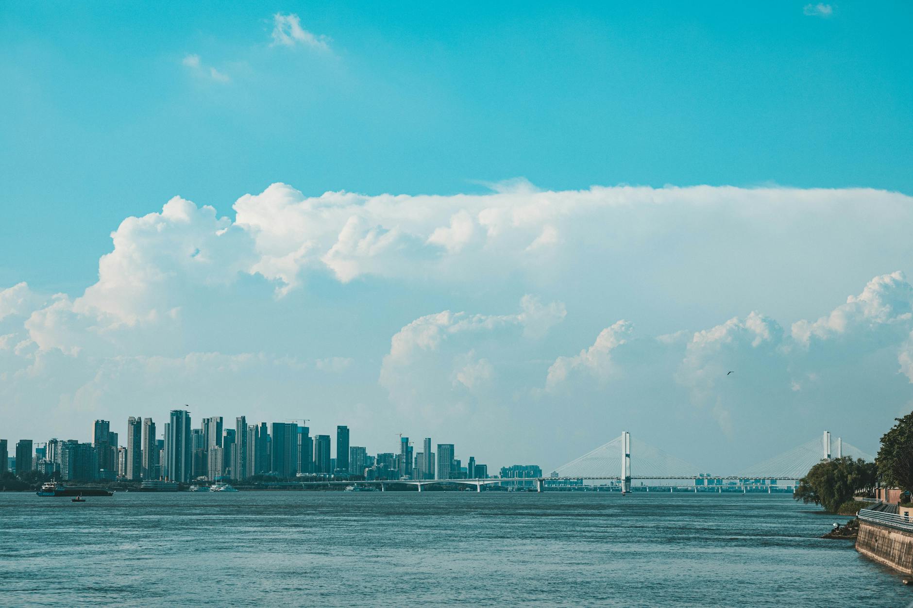 Panoramic view of a city skyline featuring a bridge over a river