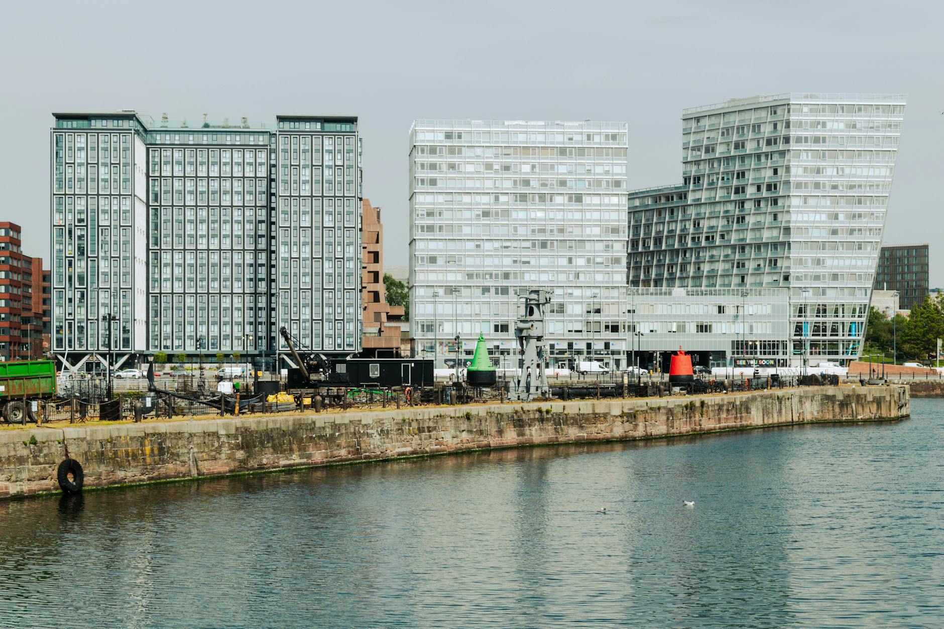 Modern buildings along Liverpool waterfront reflecting on still water